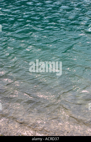 Lake with beautiful ripples in windy weather at sunset, sun rays ...