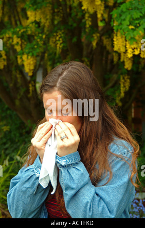 Woman sneezing into handkerchief in garden Stock Photo: 7555878 - Alamy