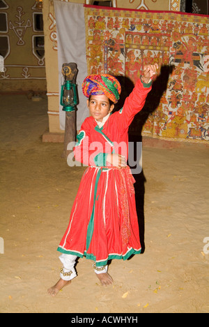 A teen age boy dancing in his traditional dress while his family ...