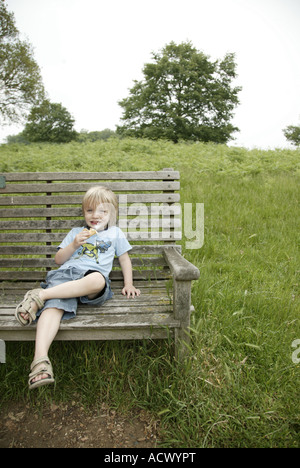 Happy toddler eating ice-cream cone. Joyful messy baby covered with ...