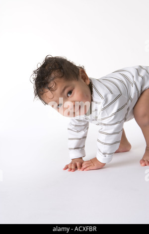 A baby boy tries to stand up by the window. The child learns to stand ...