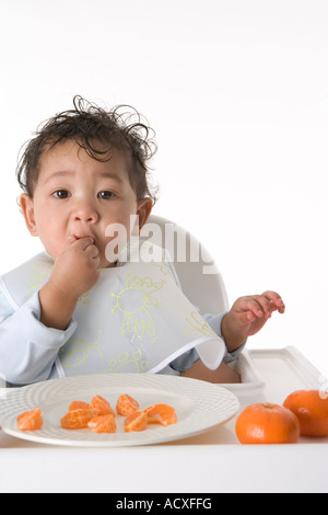 Little boy eating a mandarin Stock Photo - Alamy