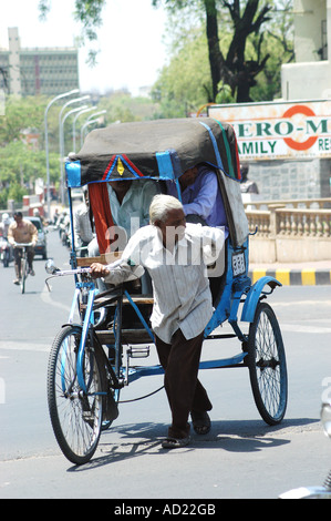 Load carrying cycle rickshaw pulling man through the market rushy ...