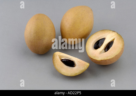 Three Chickoo two full one half cut food fruit on grey background Stock ...