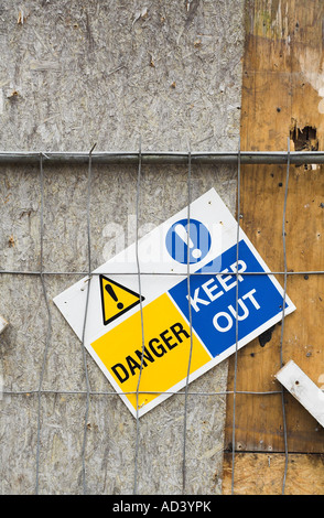 a keep out sign fixed to the security fence around a construction site ...