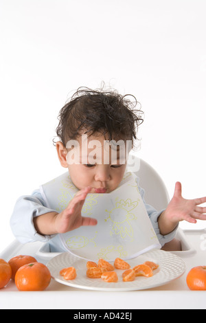 Little boy eating a mandarin Stock Photo - Alamy