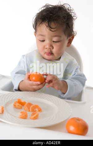 Little boy eating a mandarin Stock Photo - Alamy