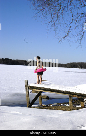 Man with inner tube ready to swim staring at frozen lake Stock Photo ...