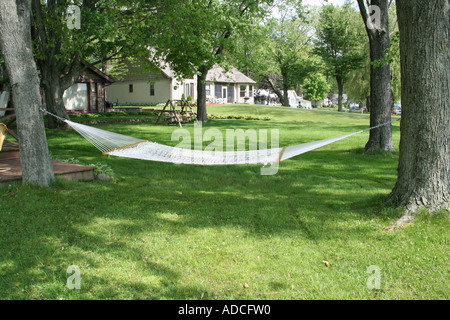 Backyard With Hammock Tied Between Trees Beside Picnic Basket Stock ...