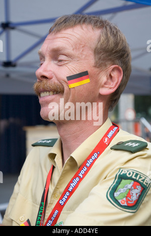 German policeman police officer wearing baseball cap talks with ...
