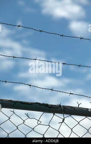 Wire fence with a blue sky with clouds of background Stock Photo - Alamy