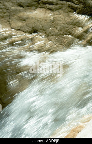 Overhead views of waterfall flowing over cliffs 100 metres to a rock ...