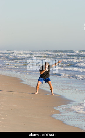 Man shadow boxing on beach while in training Stock Photo - Alamy