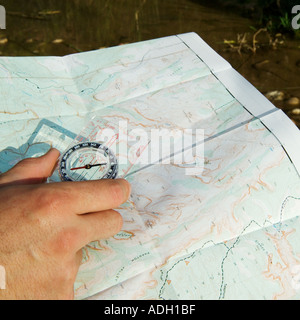 Hand holding a compass on an orienteering map Stock Photo - Alamy