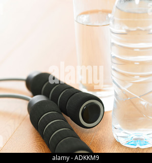 Skipping rope and bottle of water on white background Stock Photo - Alamy