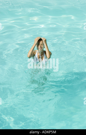 Young woman face in splashes of water over white background. Moistening ...