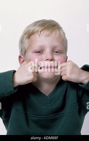 five-year-old boy making faces. A five-year-old blond boy makes faces ...