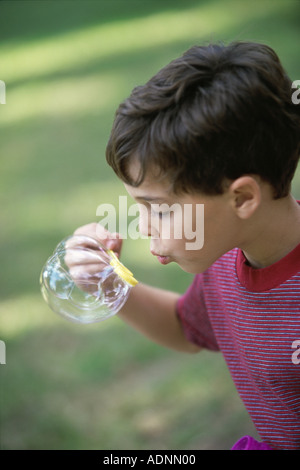 Side profile of a boy blowing bubbles with a bubble wand Stock Photo ...
