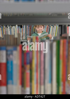 Boy in library with books Stock Photo - Alamy