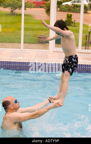 Father throwing son swimming in outdoor pool Stock Photo - Alamy