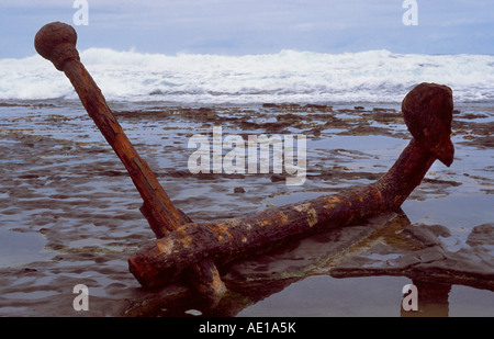 Old rusty anchor on rock by blue sea Stock Photo - Alamy