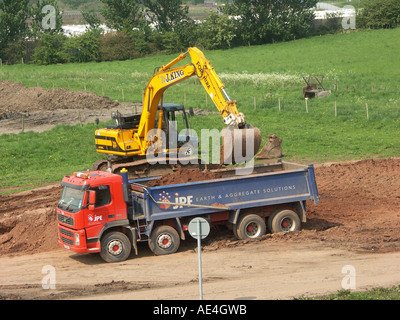 excavator loading earth onto lorry Stock Photo - Alamy