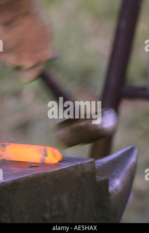 Striking a piece of hot iron on an anvil with the hammer Stock Photo ...
