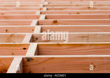 Wood blocking in a staggered pattern between floor joists at a ...
