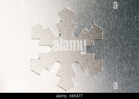 metallic snowflake punched out of thin brushed sheet metal (with a ...