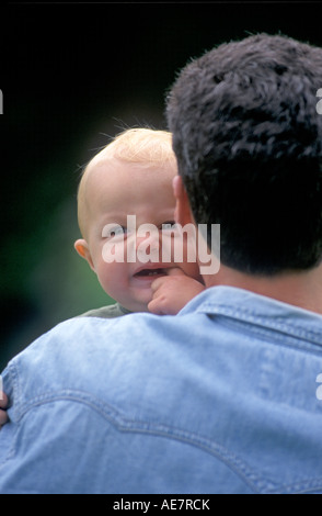 Baby boy looking over father's shoulder Stock Photo - Alamy