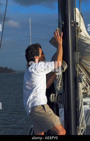 Setting sail - couple hoisting the mainsail on a sailing yacht Stock ...