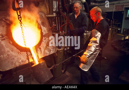 Industry. Mining. Gold Smelting. Workers pouring molten gold metal ...