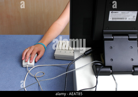 a childs hands pictured using a mouse at a pc computer station in a ...