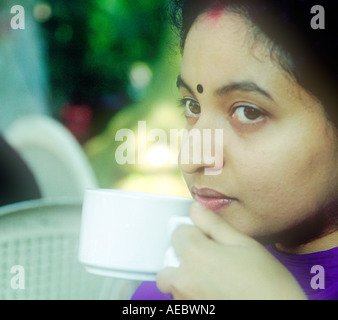A young Indian lady sipping tea Stock Photo - Alamy