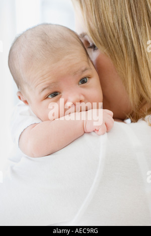 Young mother, holding her newborn baby boy, infant with santa hat ...