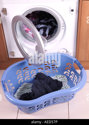 Washing machine and basket with dirty clothes in laundry room Stock ...