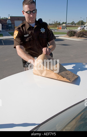 Deputy Sheriff placing confiscated evidence in bag for lab analysis ...