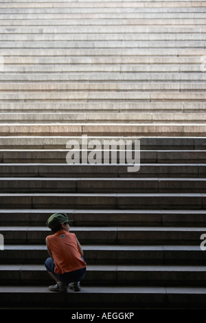 Boy crouching at bottom of steps, China Beijing Stock Photo - Alamy