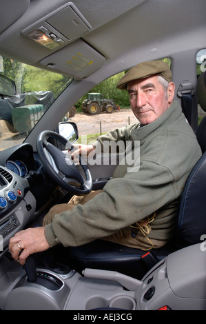PORTRAIT OF A SHEEP FARMER IN THE CAB OF A LAND ROVER DEFENDER ON A ...