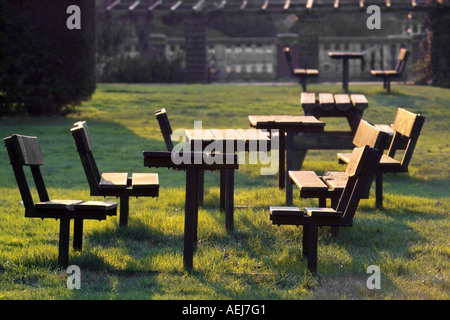 Wooden picnic tables & benches with green grass & an outdoor kettle ...
