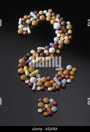 A vertical shot of colorful pills of different shapes with a spoon on a ...