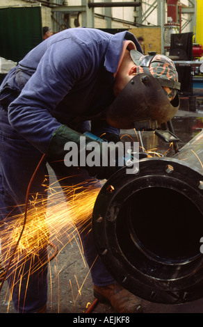 Industry man angle grinding pipework Stock Photo - Alamy