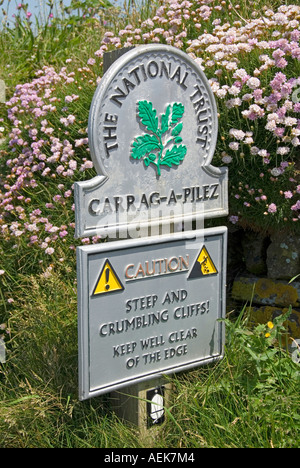 National Trust sign beside South West Coast Path walkers on hilltop ...