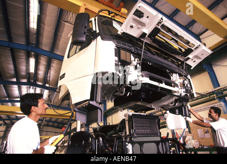 Expatriate workers install engine on truck chassis at Volvo assembly ...
