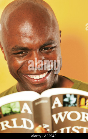 Man laughing while reading a book Stock Photo - Alamy