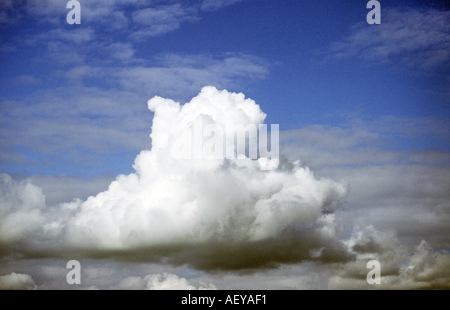 Large fluffy cumulus cloud against vivid blue sky, symbolizing weather ...