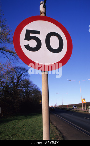50 mile per hour speed restriction road sign with car speeding past ...