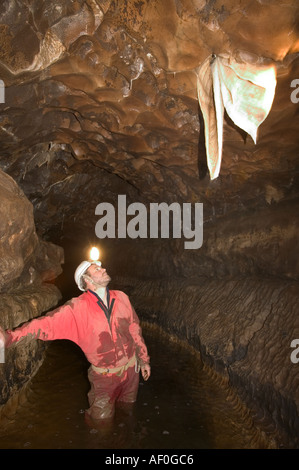a male caver in a stream passageway in the newly discovered notts II ...