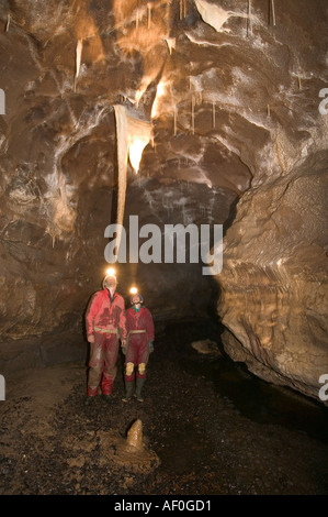 male and female cavers in Notts II cave admire formations in a stream ...