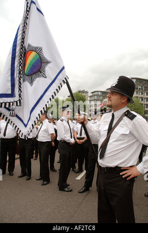 People marching at London Pride parade with rainbow flags and banners ...